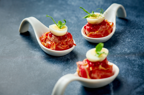 Hapje van krokant spek met wild paté, veenbessen & een kwarteleitje